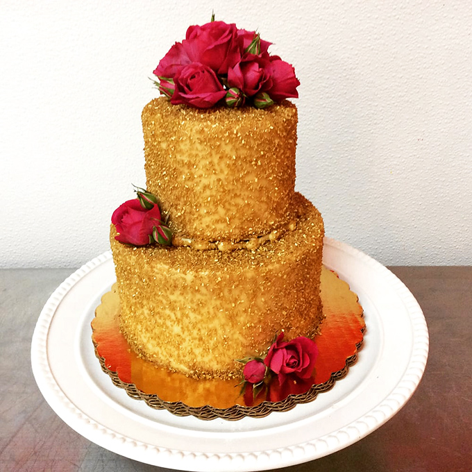 Gold-dusted elegance crowned with fresh roses. This isn't just cake&mdash;it's what Marie Antoinette would have actually meant by "let them eat cake."