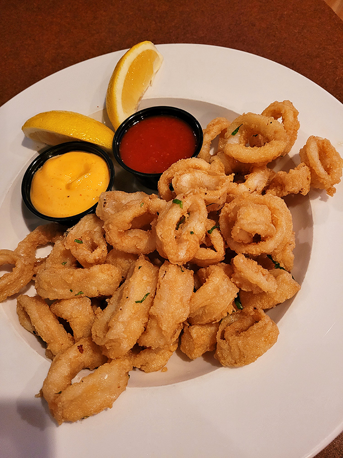 Golden perfection arrives with two dipping sauces and fresh lemon - calamari dreams realized.