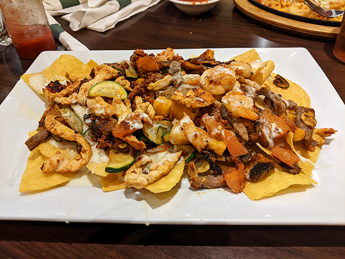 A mountain of loaded nachos that requires a climbing permit &ndash; layers of protein, veggies, and cheese creating a delicious expedition.