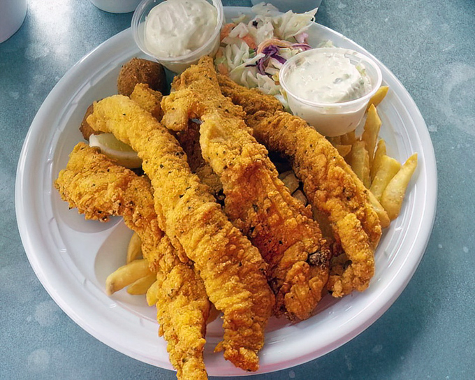 Golden-crusted catfish that practically winks at you from the plate. The cornmeal coating crackles with each bite, while the fish inside stays impossibly tender.