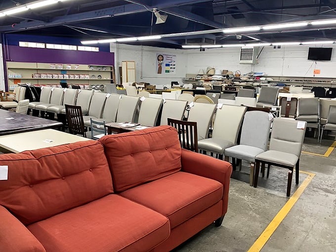 Red sofas and white dining chairs stand at attention like hopeful contestants on a furniture dating show.