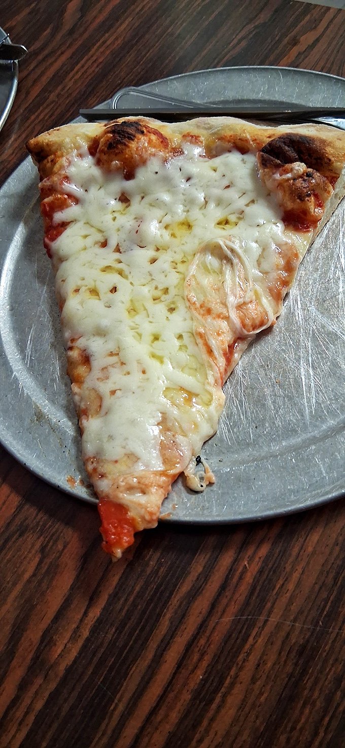 The star of the show: a slice of cheese pizza with that perfect cheese-pull that makes you temporarily forget your table manners.