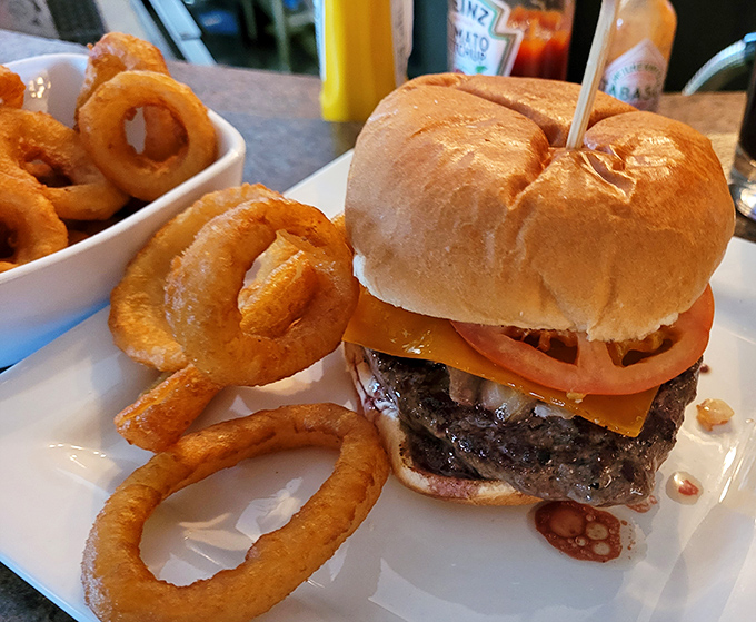 This isn't just a burger, it's a masterpiece of beef architecture with golden onion rings standing guard like delicious sentinels.