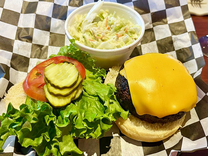 Behold the headliner: a perfectly charred burger with melted cheese that performs the slow, seductive dance of dairy meeting beef.