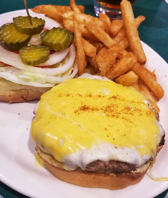 This isn't just a cheeseburger; it's a masterclass in simplicity. Golden-crisp fries, tangy pickles, and a patty that makes fast food chains weep with inadequacy.