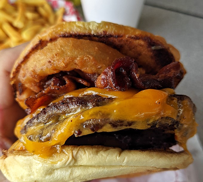 This isn't just a cheeseburger&mdash;it's edible architecture. The melted cheese cascading over the patty like a yellow waterfall of happiness.