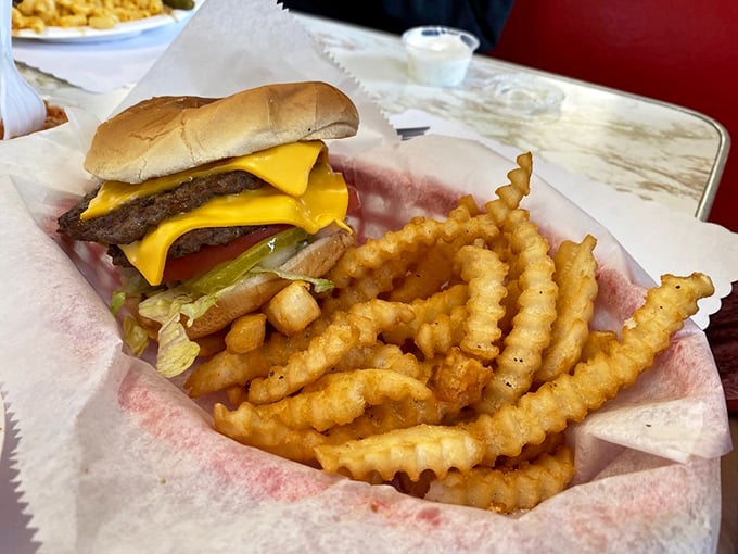 This isn't just a cheeseburger; it's a masterclass in American comfort food geometry, with those perfectly crinkled fries standing at attention alongside.