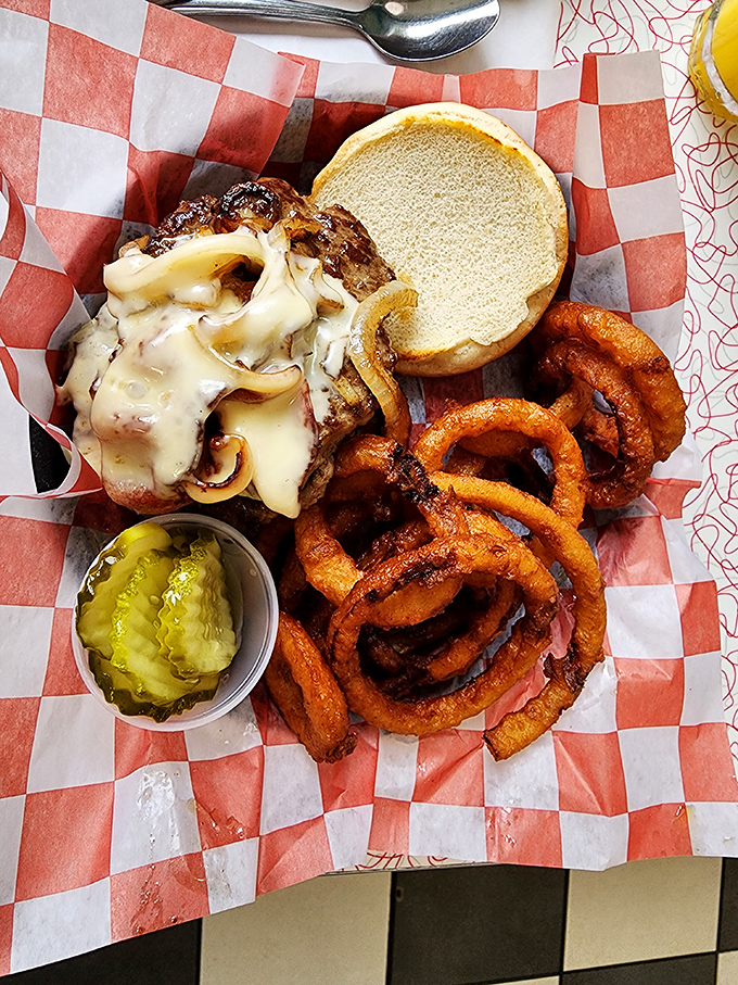 Mushroom Swiss burger nirvana with a side of onion rings that could double as edible bracelets. The pickle cup is practically mandatory etiquette.