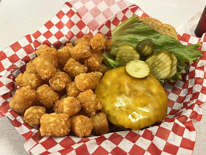 Golden tots that crunch like nature's perfect percussion instrument alongside a cheeseburger that's been perfecting its craft since before your parents' first date. 