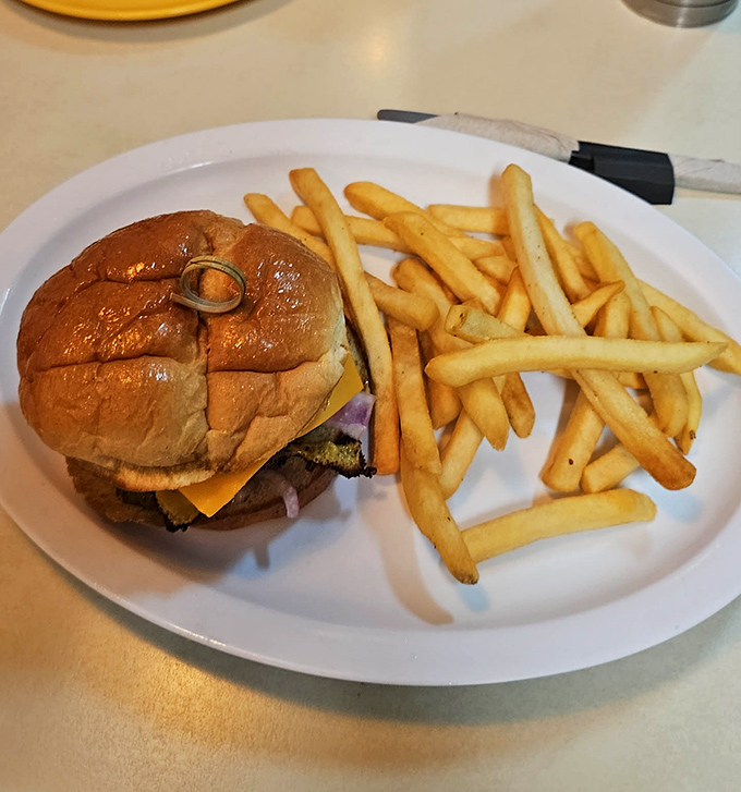 Behold, the burger in its natural habitat&mdash;unpretentious, perfectly grilled, and flanked by an honor guard of golden fries standing at attention.