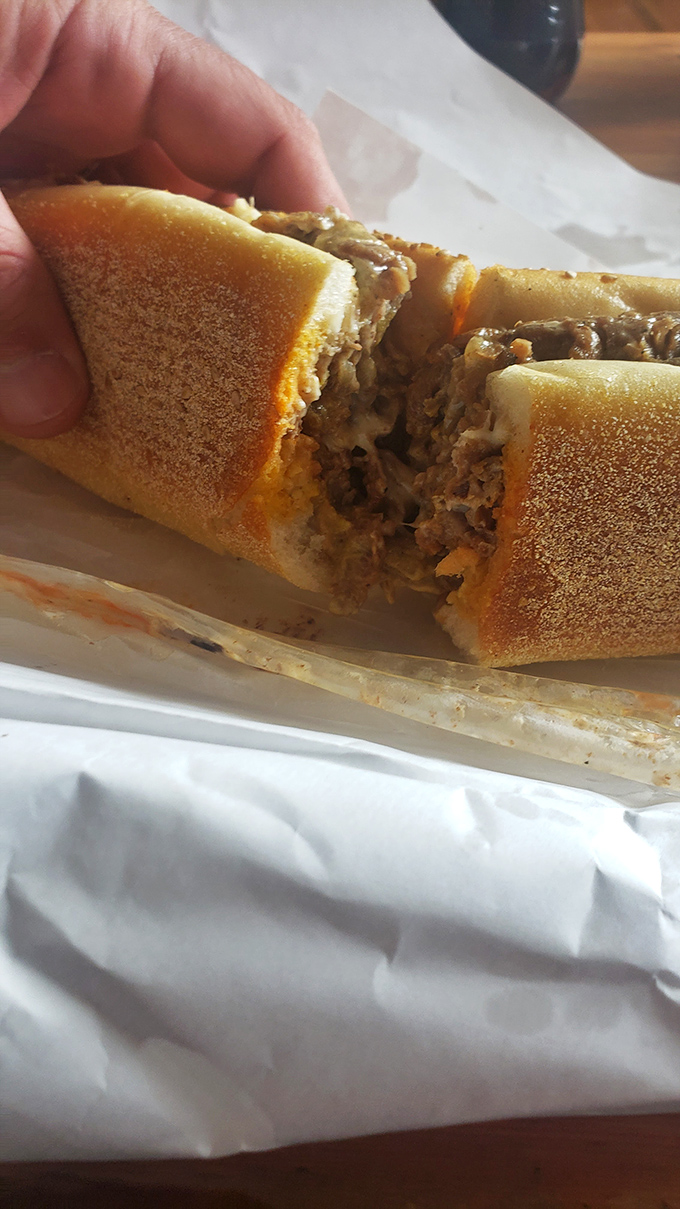The cheesesteak cross-section reveals the truth – properly chopped meat, melted cheese, and a roll that's both sturdy and yielding. Philadelphia's soul in sandwich form.