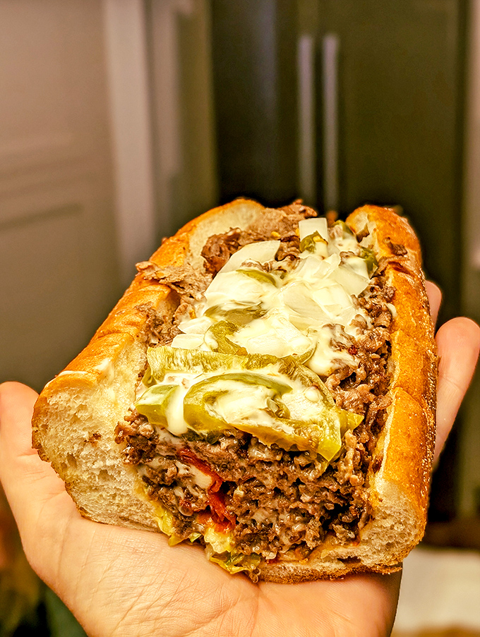Behold the architectural marvel that is a proper cheesesteak &ndash; cheese cascading like delicious lava over perfectly seasoned beef.