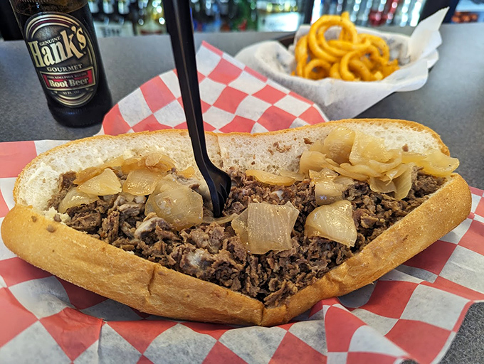 Behold the star of the show &ndash; thinly sliced ribeye, perfectly caramelized onions, all nestled in a roll that's both sturdy and yielding. Sandwich architecture at its finest.