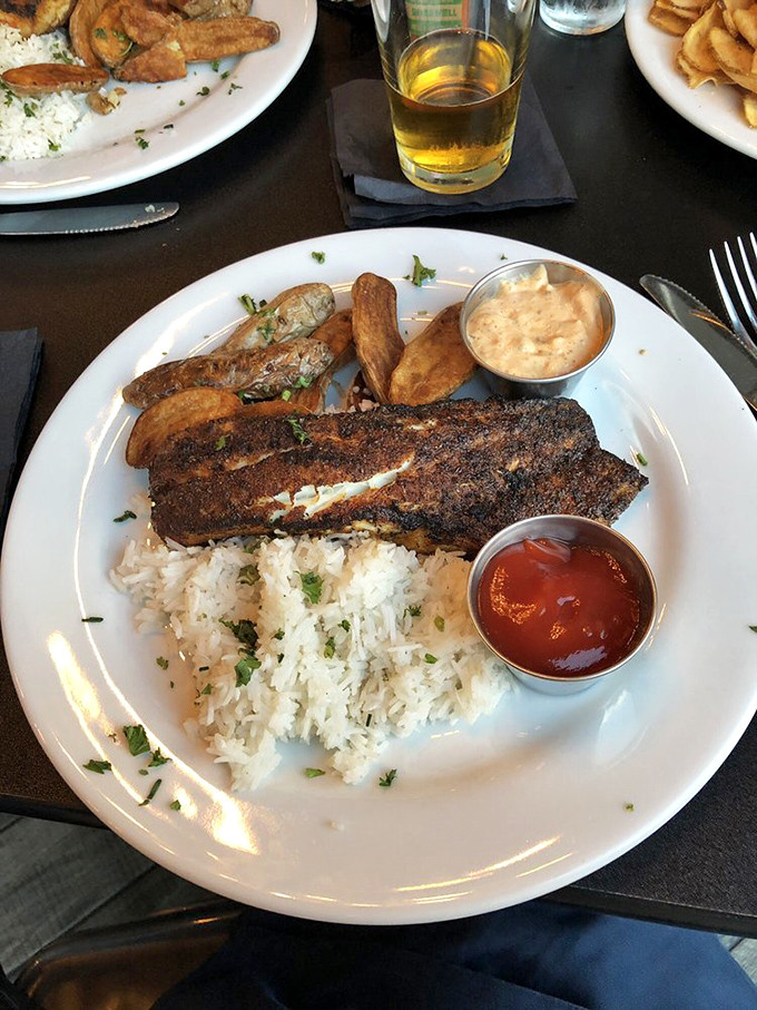 Blackened Chesapeake Bay Rockfish arrives like a celebrity, perfectly seared and ready for its culinary close-up.