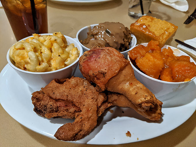 Behold the star of the show: golden-fried chicken with mac and cheese, candied yams, and cornbread. This isn't a meal; it's an event.