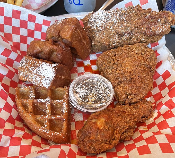 Heaven exists on a red checkered paper&mdash;golden chicken with crackling skin nestled against powdered waffles, with maple syrup standing by for the perfect union.