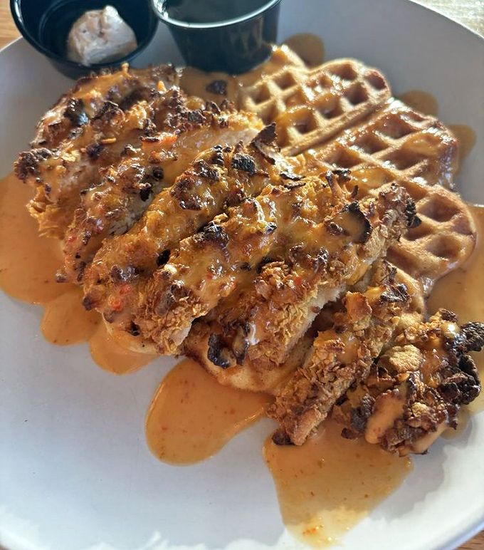 Chicken and waffles: where savory meets sweet in a dance so perfect, it deserves its own Broadway show. That maple syrup river? Pure gold.