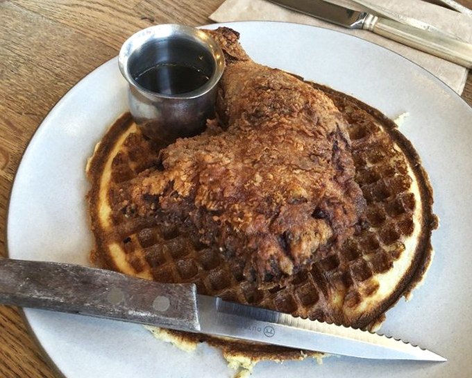 Behold the main event: fried chicken so gorgeous it could win a beauty pageant, lounging on its waffle throne.