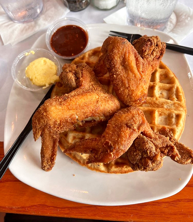 Behold the star attraction: golden-fried chicken perched atop a perfect waffle, with shmear and sauce standing by for their supporting roles.