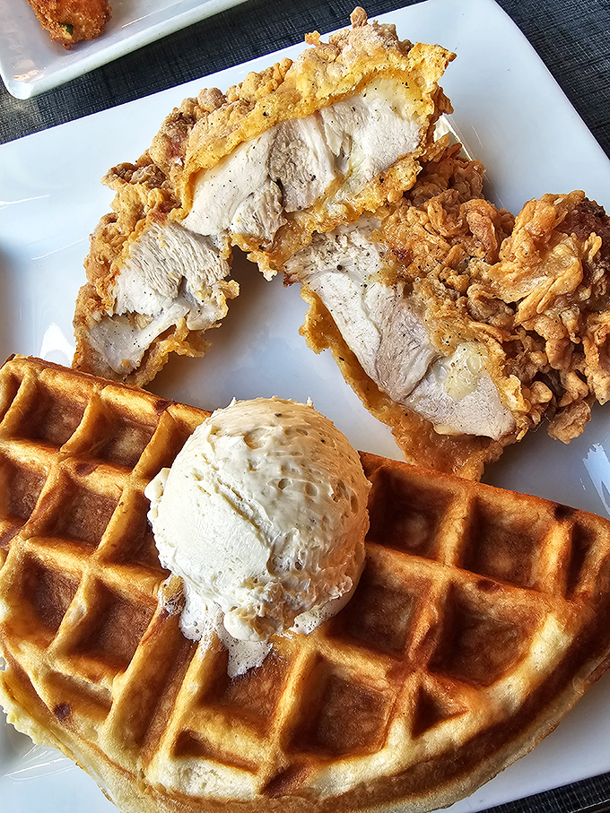 The star attraction: golden-brown chicken perched atop a Belgian waffle with a scoop of brown sugar butter melting seductively. Poetry on a plate.