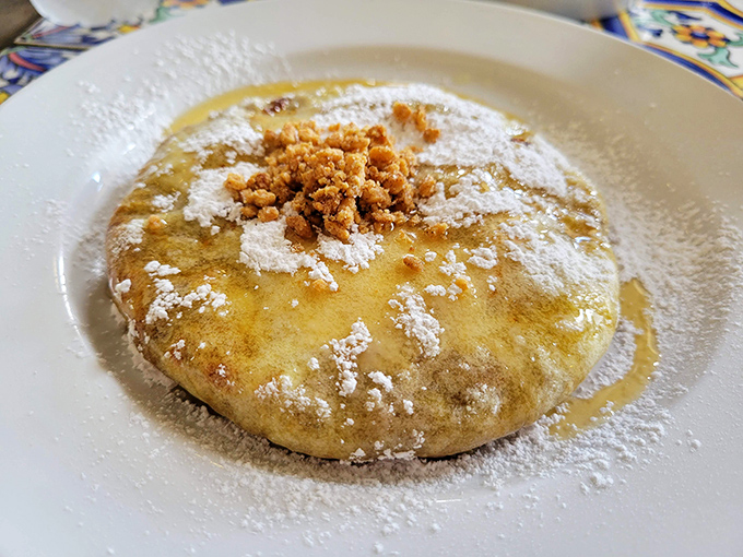 The star of the show: Chicken Bastilla dusted with powdered sugar and cinnamon, hiding a savory filling that creates the most delicious identity crisis a dish could have.