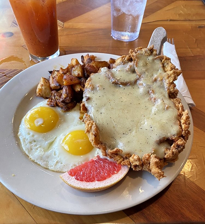Behold the star attraction: a chicken fried steak that extends beyond its plate's boundaries, smothered in gravy that could make a vegetarian reconsider their life choices.
