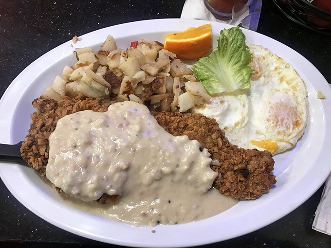 Behold the star attraction: chicken fried steak that laughs in the face of diet plans, smothered in gravy that could make a vegetarian reconsider life choices.