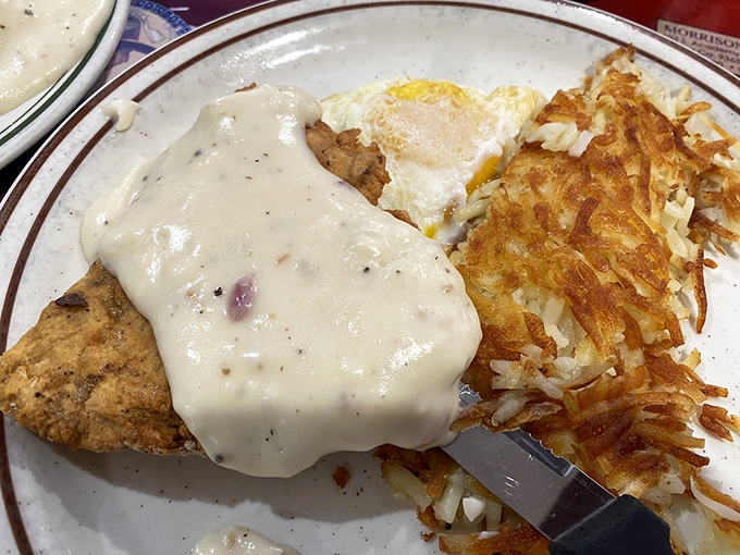 Country-fried steak smothered in gravy that could make a grown cowboy weep, paired with hash browns crispy enough to make beautiful music with your fork.