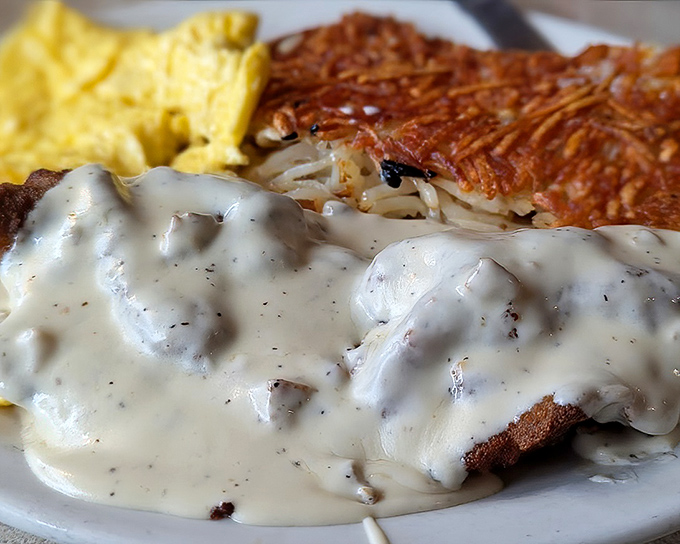 Behold the star attraction: chicken fried steak swimming in peppery country gravy. This isn't a meal; it's a religious experience with hash browns.