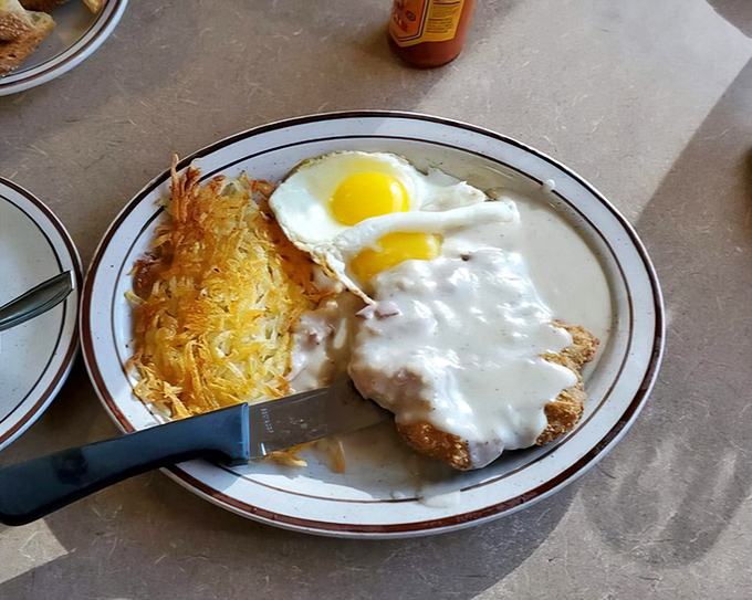 Country fried steak with gravy so good you'll want to write home about it, alongside hash browns that achieve golden perfection.