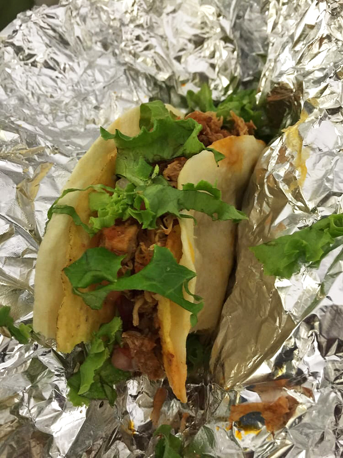 Behold the star of our show: a chicken taco cradled in foil like the culinary treasure it is. That fresh cilantro isn't just garnish&mdash;it's a promise.