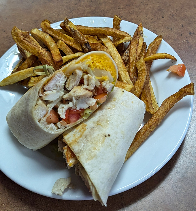 The legendary chicken wrap in its natural habitat: perfectly grilled, generously stuffed, and flanked by hand-cut fries that deserve their own fan club.