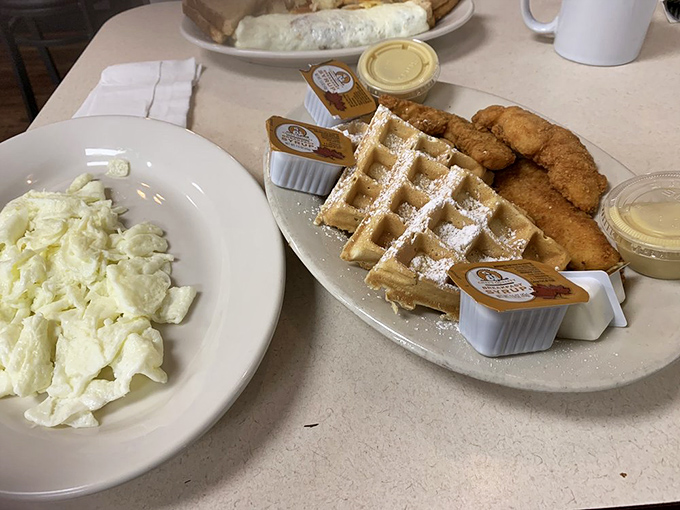 Behold the star attraction: golden-fried chicken alongside a perfectly formed waffle, dusted with powdered sugar&mdash;a sweet and savory symphony.