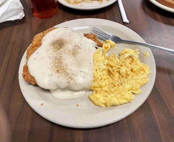Behold the holy grail of Texas cuisine: chicken fried steak smothered in pepper-flecked gravy, with scrambled eggs playing a delicious supporting role.