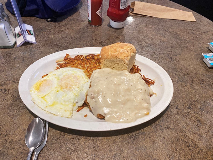 Behold: the chicken fried steak in its natural habitat, swimming in gravy with eggs and hash browns standing by for backup.