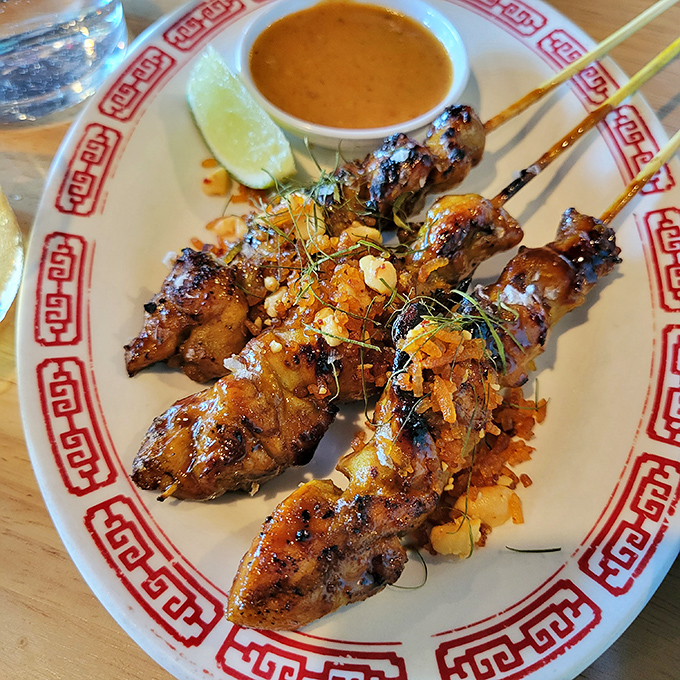 Chicken satay that's been kissed by fire and dressed to impress. That peanut sauce? I'd happily bathe in it.