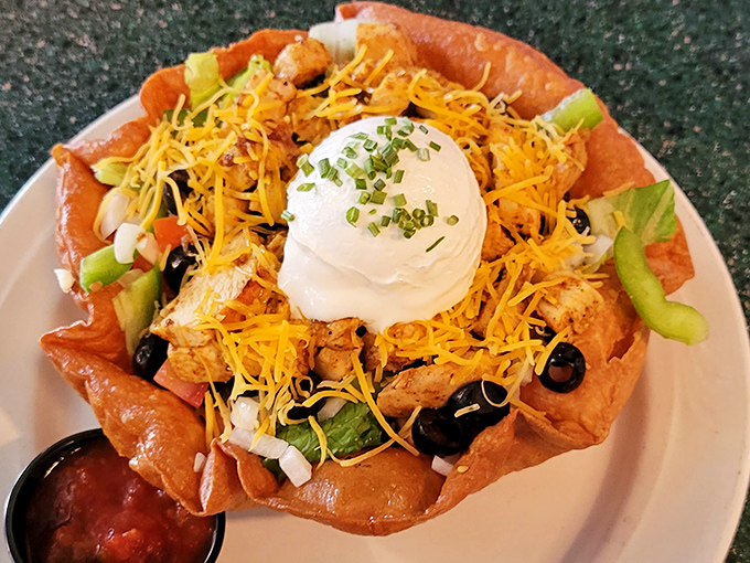 Behold the legendary chicken taco salad in all its glory—a crispy tortilla bowl cradling perfectly seasoned chicken, fresh veggies, and that dollop of sour cream that makes everything better.