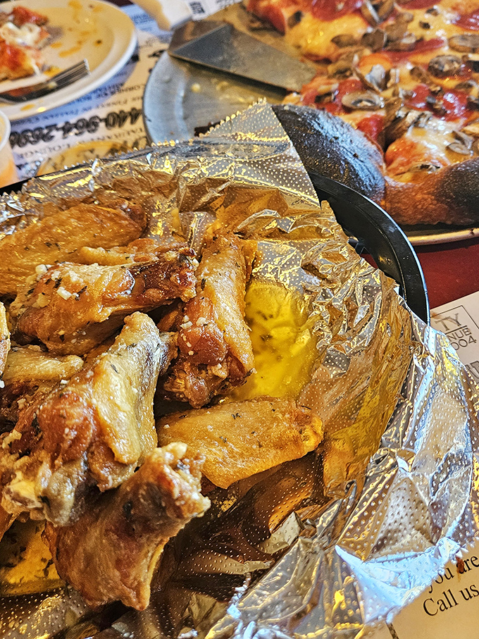 Golden-brown wings nestled in foil &ndash; the humble presentation belies the flavor explosion waiting to happen. These aren't just wings; they're edible joy.