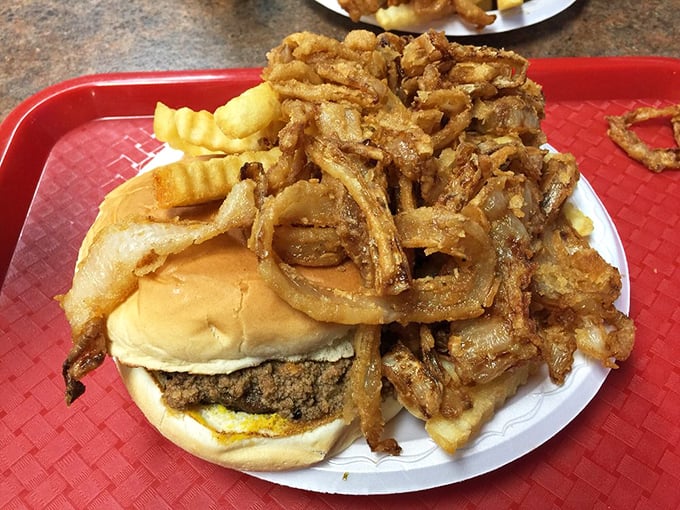 Behold the legendary "A-Plenty" in its natural habitat&mdash;a burger avalanched under a mountain of crispy onion rings and fries.