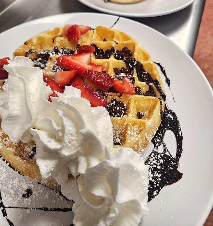 Behold the star attraction: a chocolate waffle crowned with fresh strawberries and whipped cream that makes "breakfast dessert" sound less like an indulgence and more like a necessity.