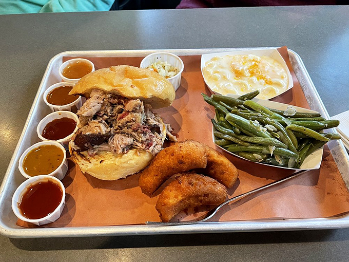 Behold the star of the show: a chopped pork sandwich accompanied by its supporting cast of sauces, hush puppies, and sides.