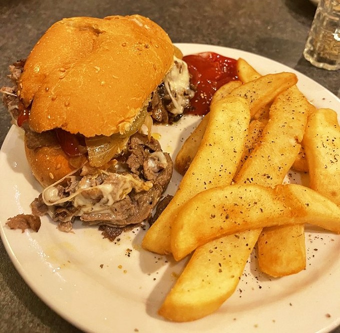 Behold the legendary chopped steak sandwich in all its messy glory, flanked by golden fries that demand to be devoured one by one.