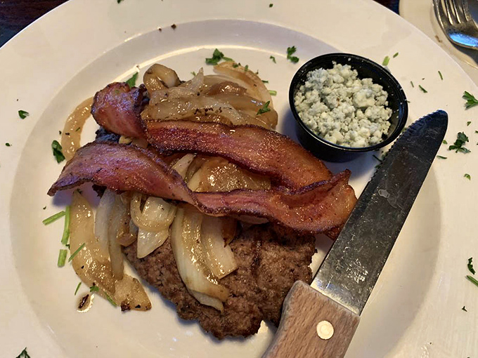 A perfectly seasoned steak topped with caramelized onions and bacon. The blue cheese side cup isn't optional&mdash;it's essential bliss.