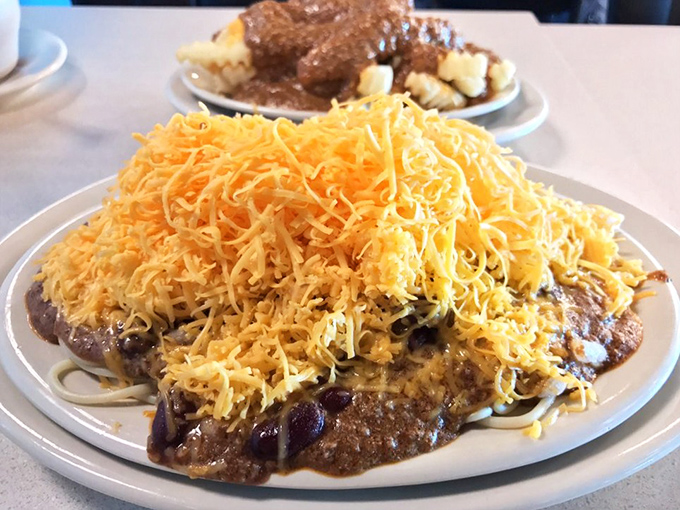 Behold the legendary Cincinnati five-way: a mountain of finely shredded cheddar atop spiced chili, spaghetti, beans, and onions&mdash;architecture you can eat.