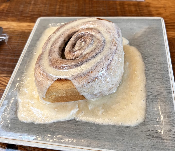 Behold the star attraction: a cinnamon roll so magnificent it deserves its own zip code. That pool of frosting isn't just decoration&mdash;it's liquid happiness.