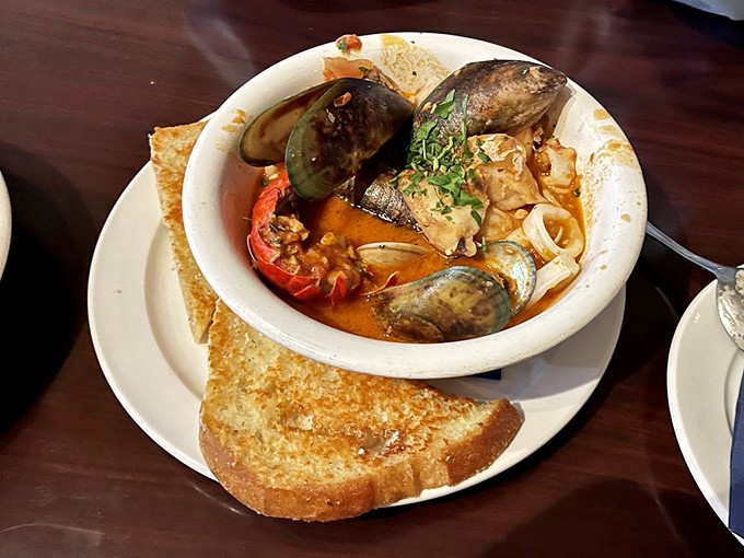 The legendary cioppino arrives like a seafood summit meeting, where crab, mussels, and fish gather in a tomato-wine broth parliament.