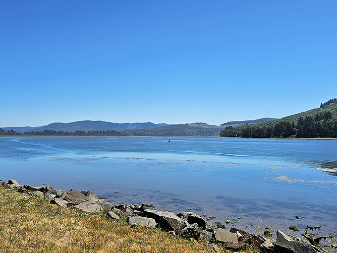 Nehalem Bay's glassy waters reflect the surrounding hills with mirror-like precision. Serenity doesn't get more photogenic than this.