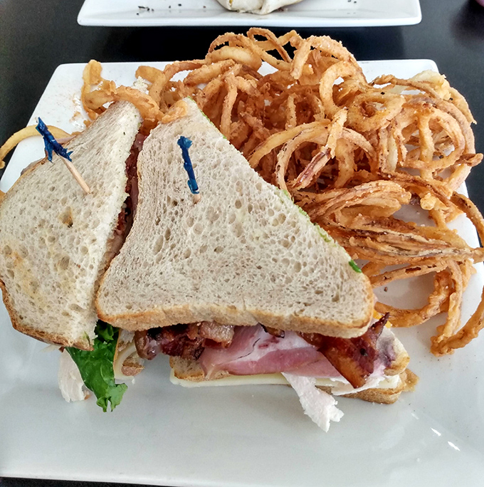 
The legendary club sandwich in all its glory&mdash;perfectly stacked layers of meat and veggies held together by toasted bread and blue toothpicks of ambition. 