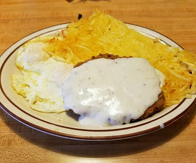 Country fried steak nirvana: crispy golden coating, tender meat, and that pepper-flecked gravy cascading over the top. Breakfast perfection doesn't need to be complicated.
