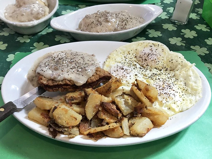 Behold the holy trinity of breakfast perfection: golden country fried steak smothered in pepper-flecked gravy, sunny eggs, and crispy home fries.